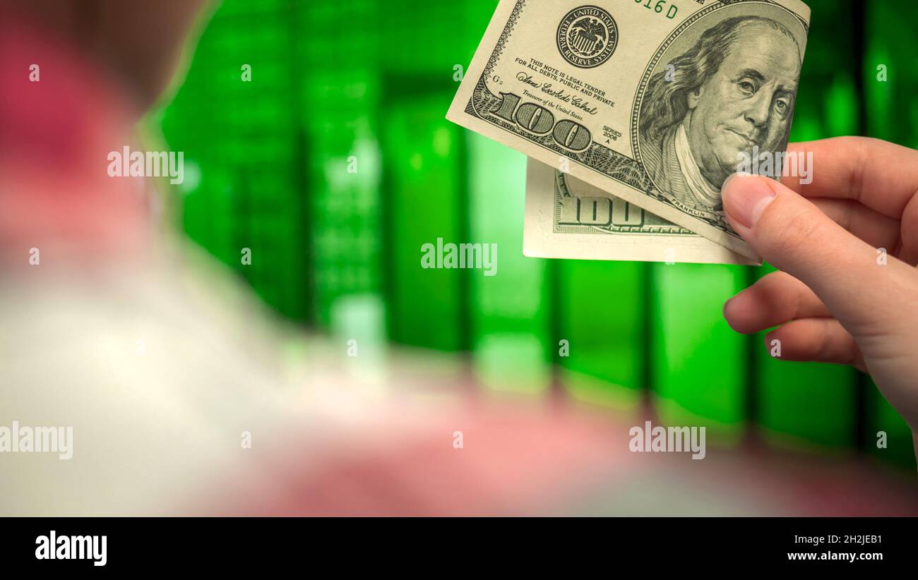 Hand with dollar bill. Trading graph and green candlestick chart on a ...