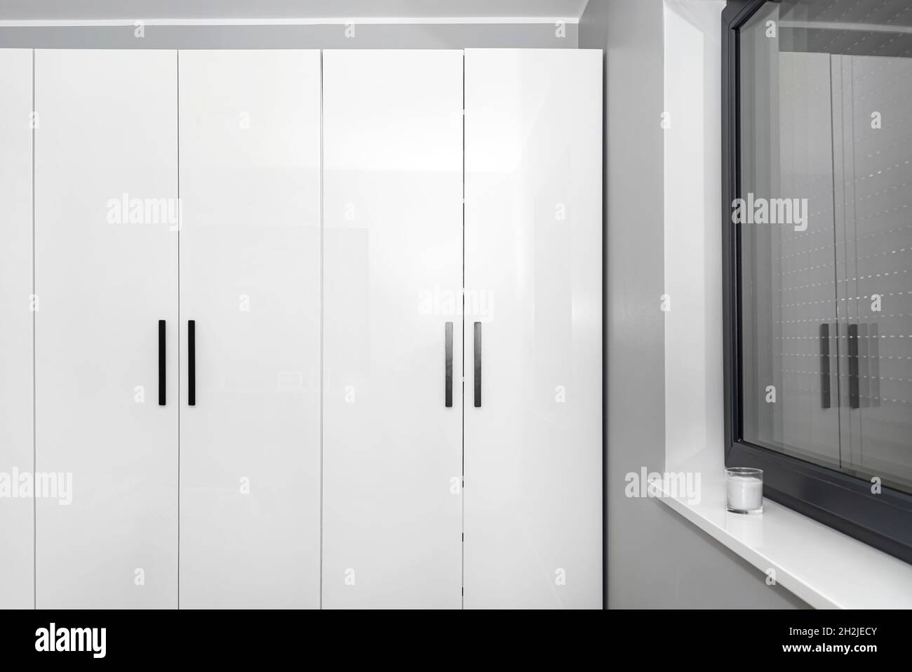 Large and high wardrobe in the bedroom with white fronts and black ...