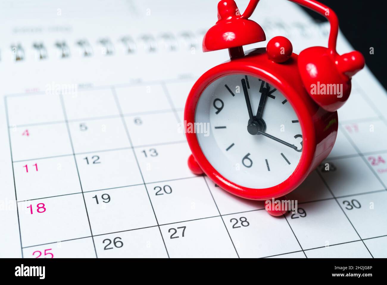 Classic clock stands on a paper calendar with a month by day Stock ...