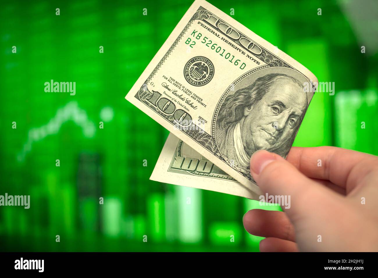 Dollar up on a green business stock chart background in hand ...