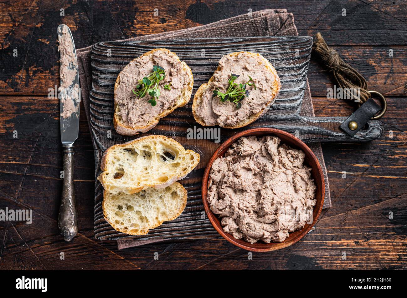 Toasts with Duck pate Rillettes de Canard on wooden board. Dark wooden ...