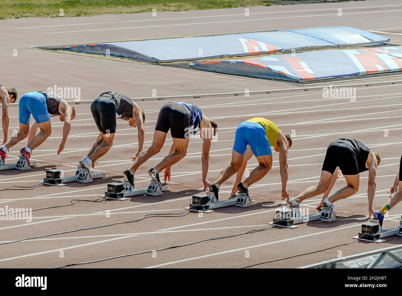 group runners athletes in starting blocks at athletics competition ...