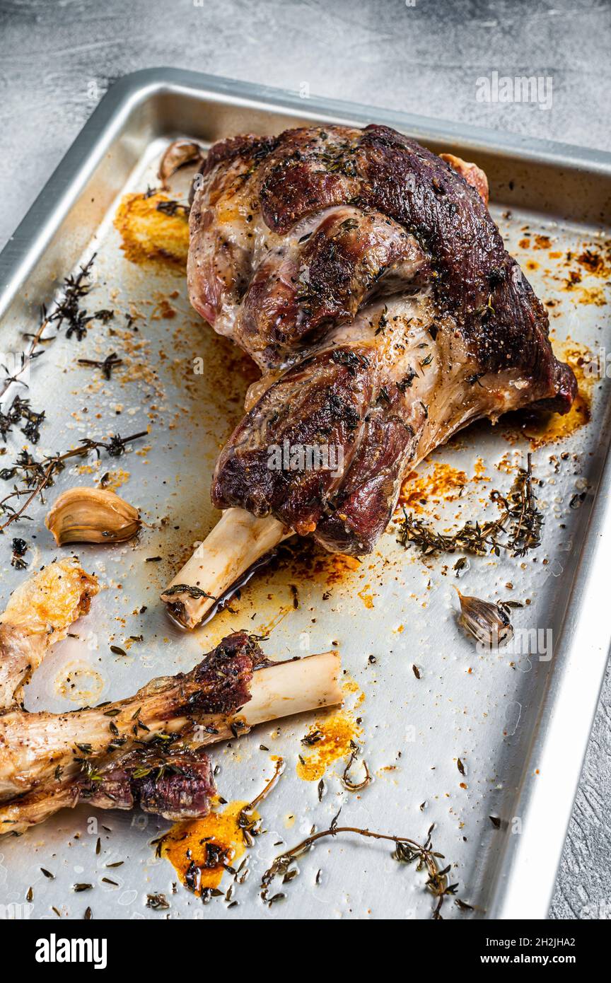 Roasted lamb mutton whole leg in a baking dish. White background. Top ...