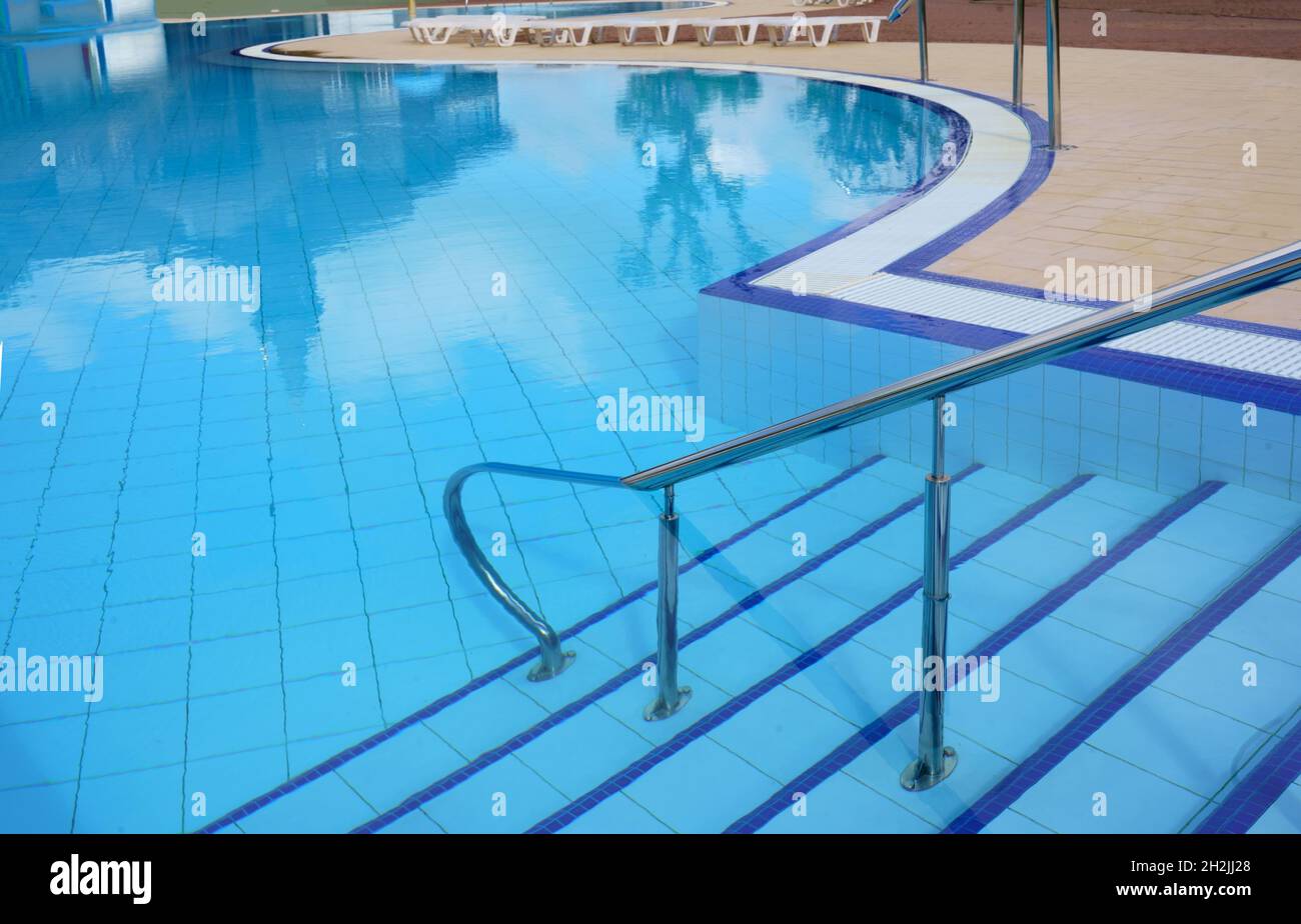 Grab bars ladder in the blue swimming pool Stock Photo - Alamy