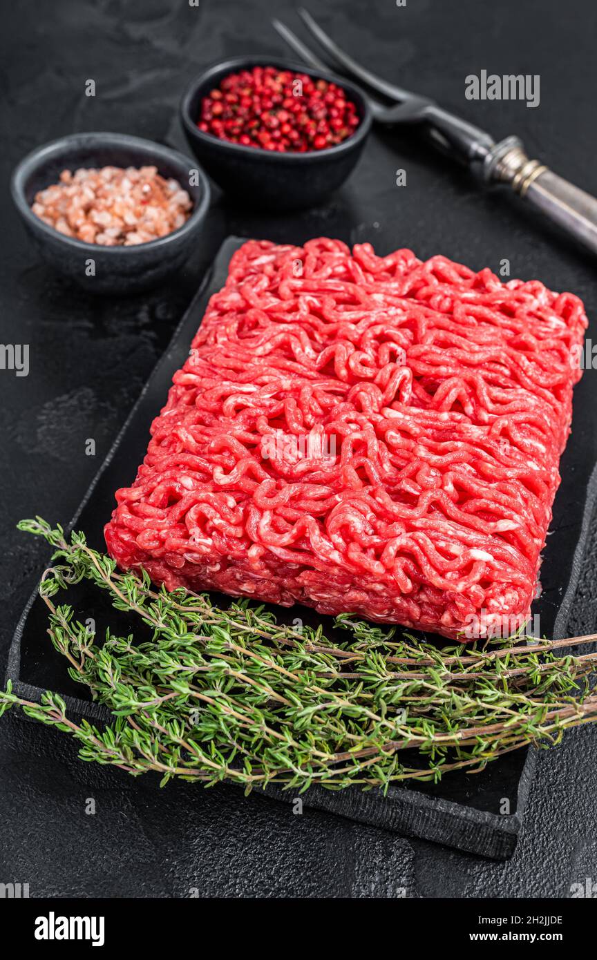 Fresh Raw Mince Ground beef meat with thyme. Black background. Top view ...