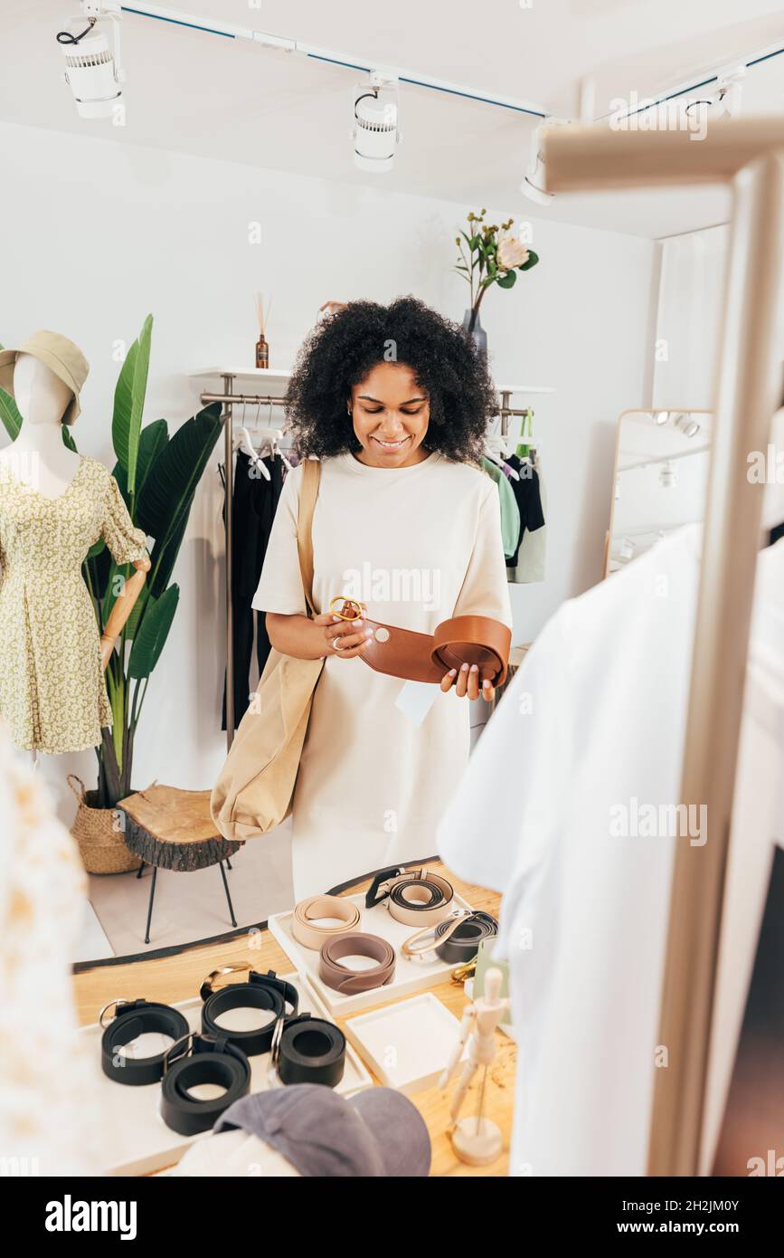 Stylish woman choosing accessories for clothes in a small local ...