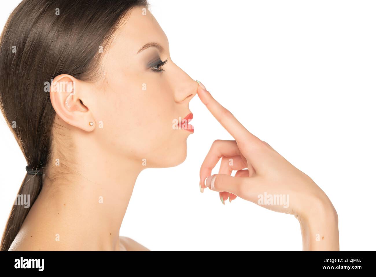 profile of a young woman touching her nose on a white background Stock ...