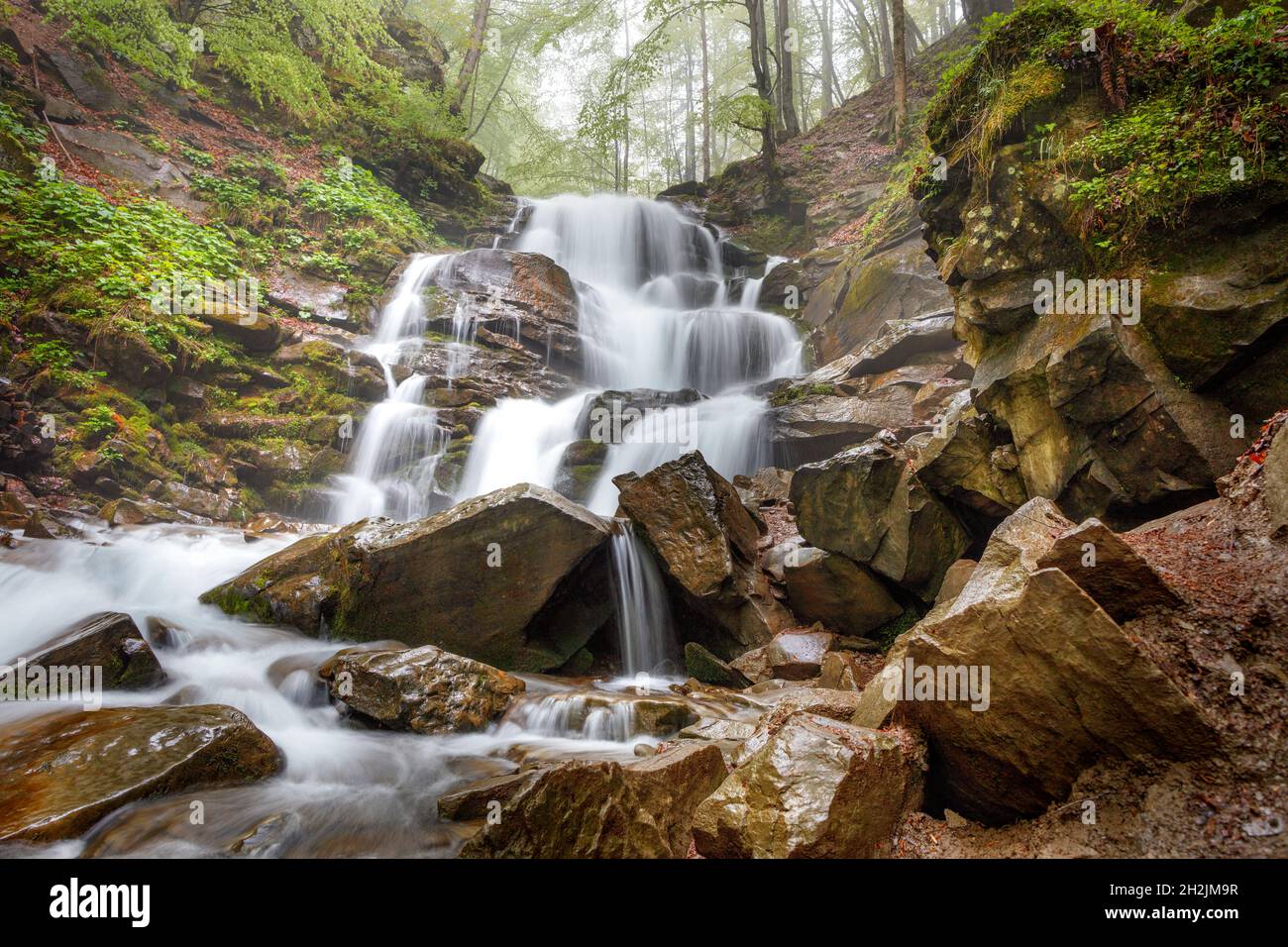 In early spring, the waters of the mountain river rush in a cool and ...