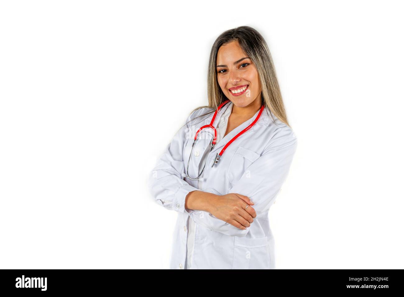 a Young Latina doctor with a big smile standing with her arms crossed ...