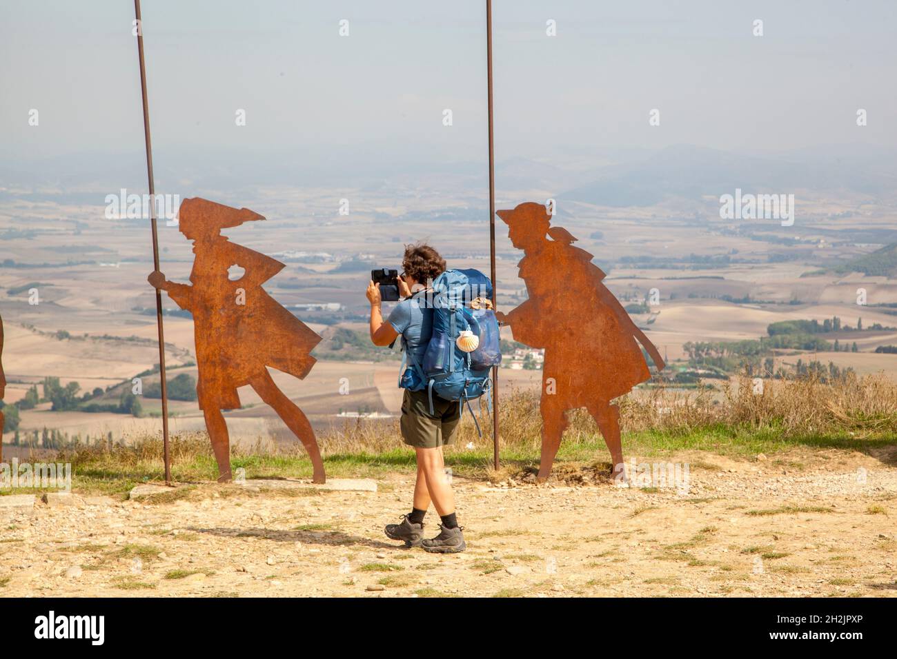 Pilgrims walking the Camino de Santiago the Way of St James on the Alto ...