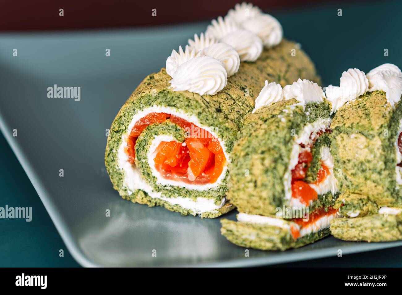 Chopped roll with spinach and red fish on square plate Stock Photo - Alamy