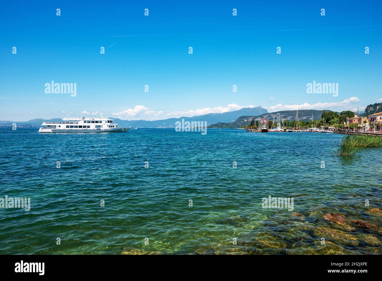 Ferry boat is arriving in the small port of the village of Bardolino ...