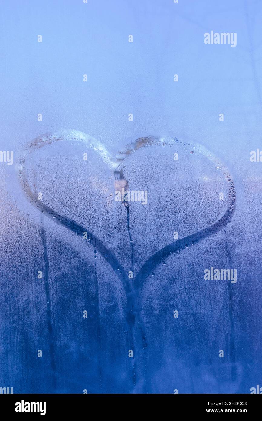 heart drawn on cold foggy glass with dark blue background Stock Photo ...