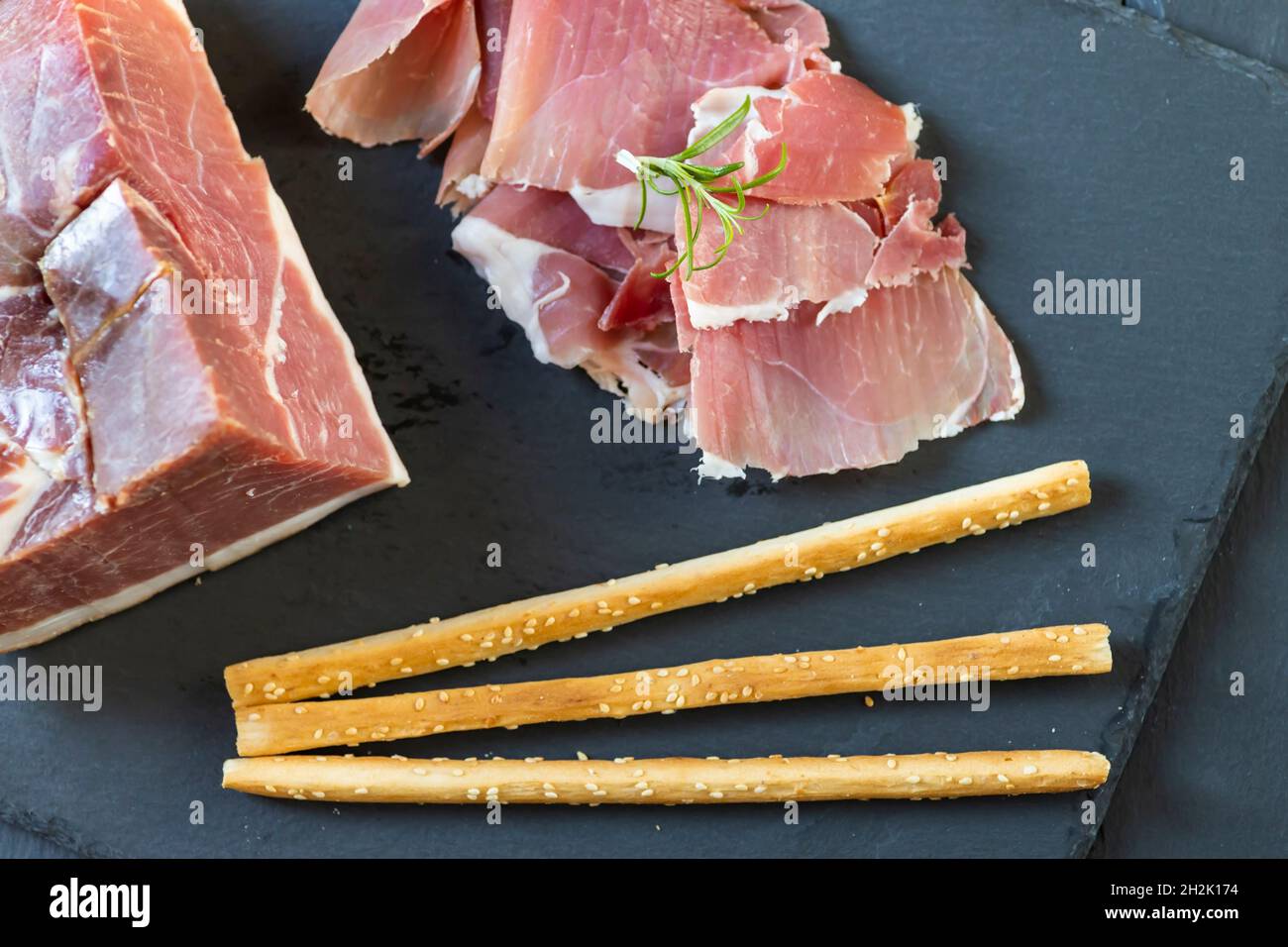 Italian ham served with grissini Stock Photo - Alamy