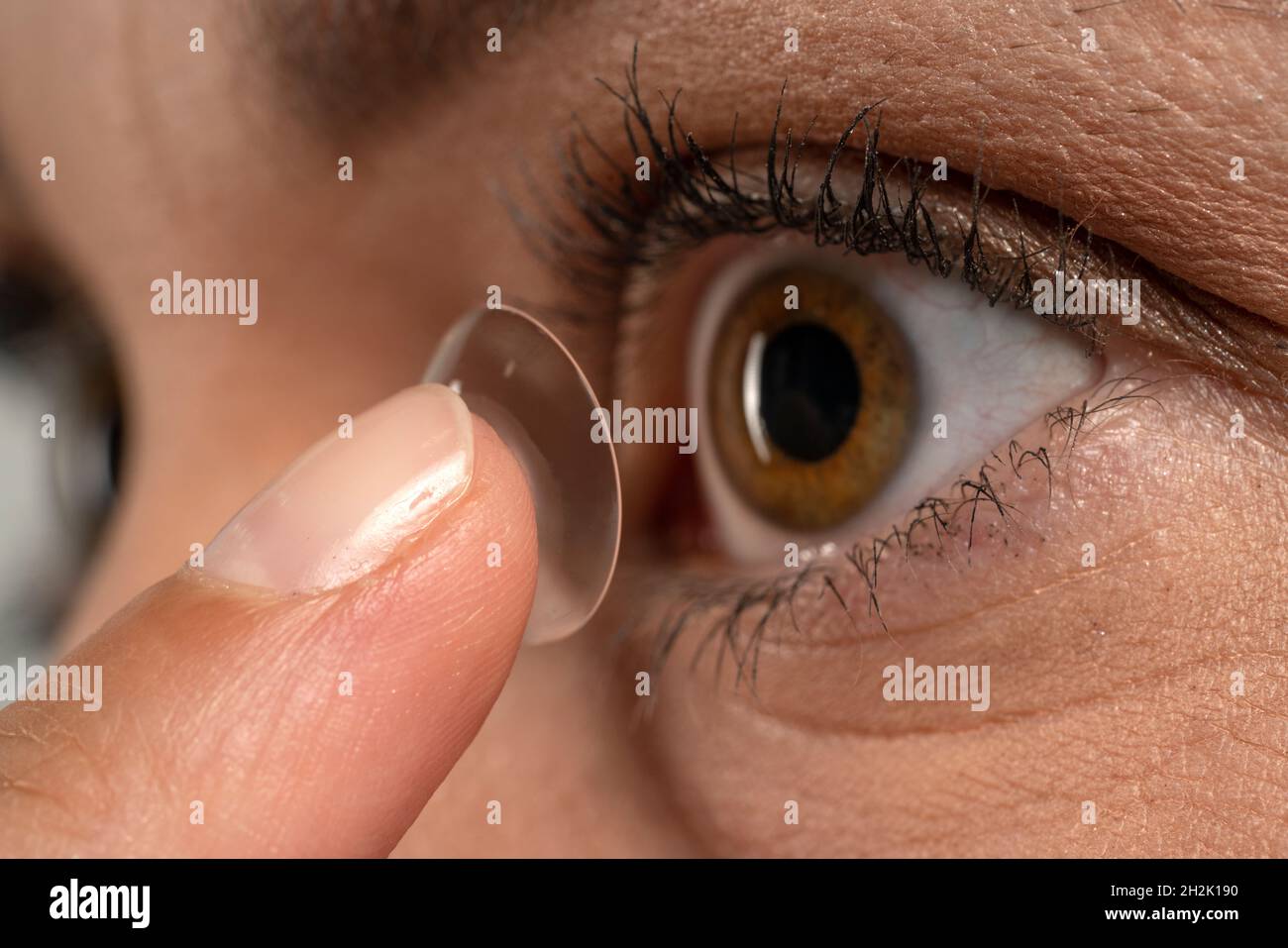Close-up shot of young woman wearing contact lens Stock Photo - Alamy