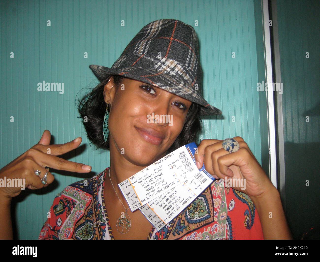 Woman in plaid fedora is happily showing off concert tickets Stock ...