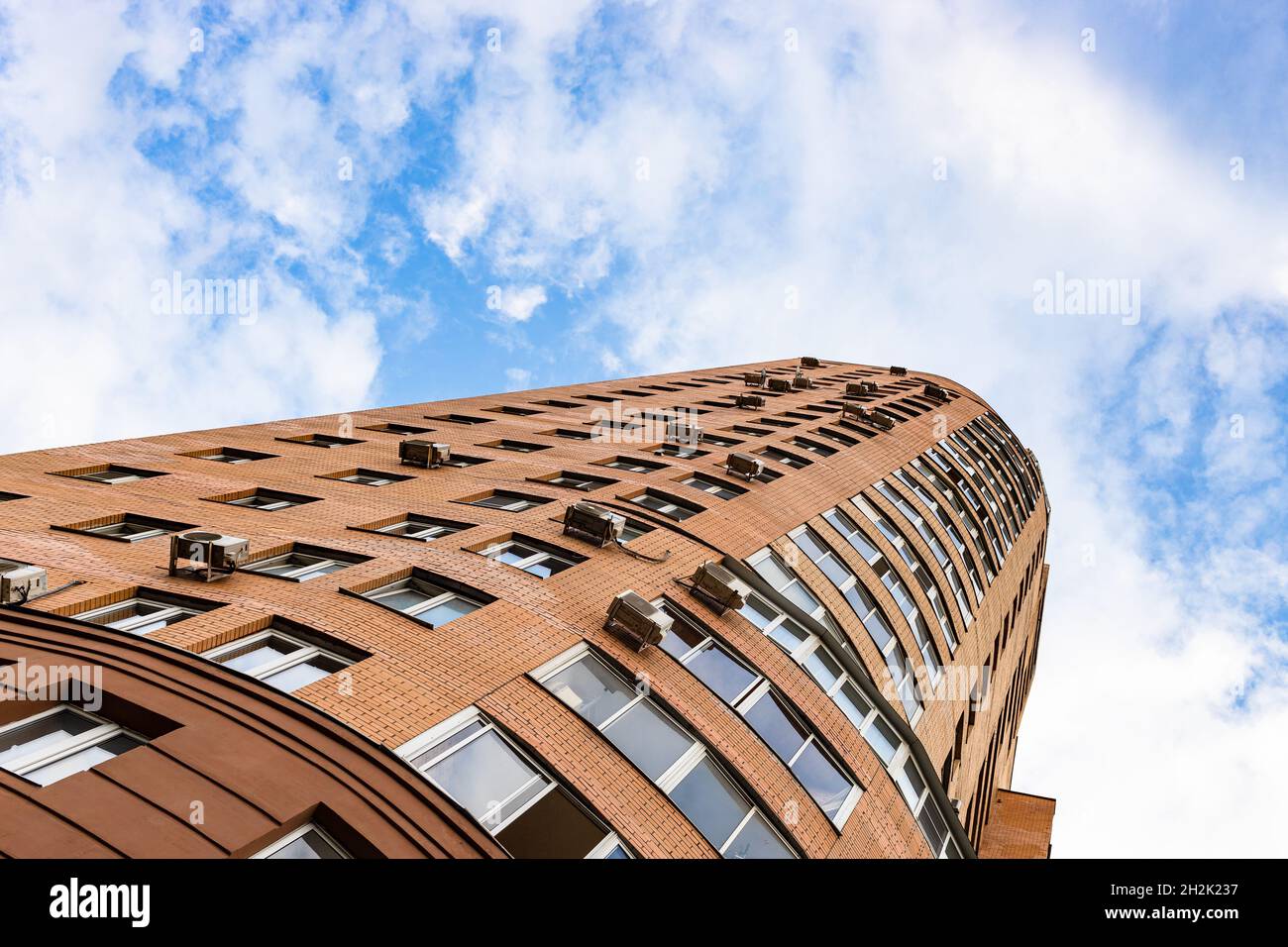 bottom view of high-rise brick house and white clouds in blue sky Stock ...