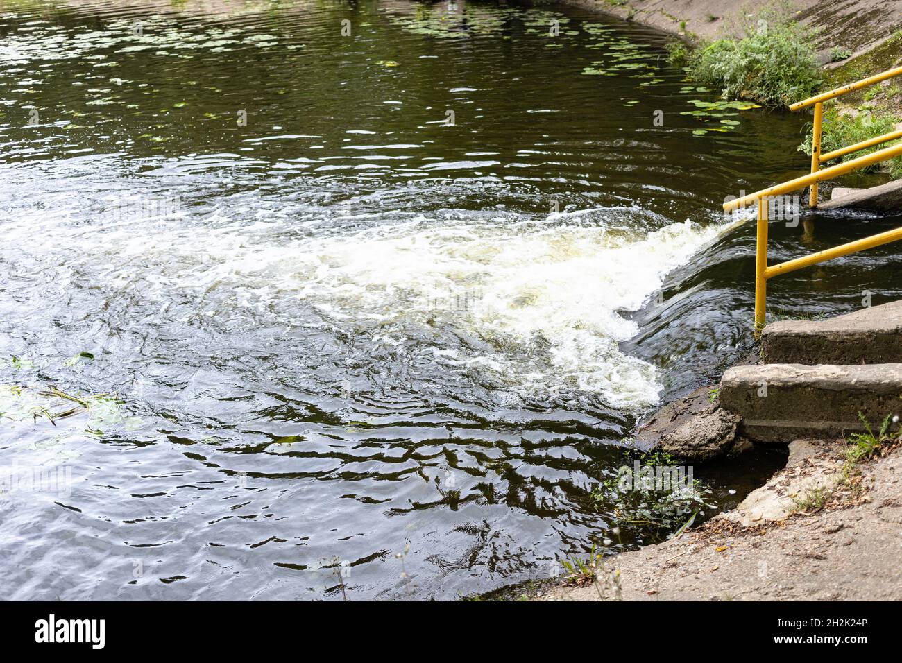 discharge of water from underground river into city pond Stock Photo ...