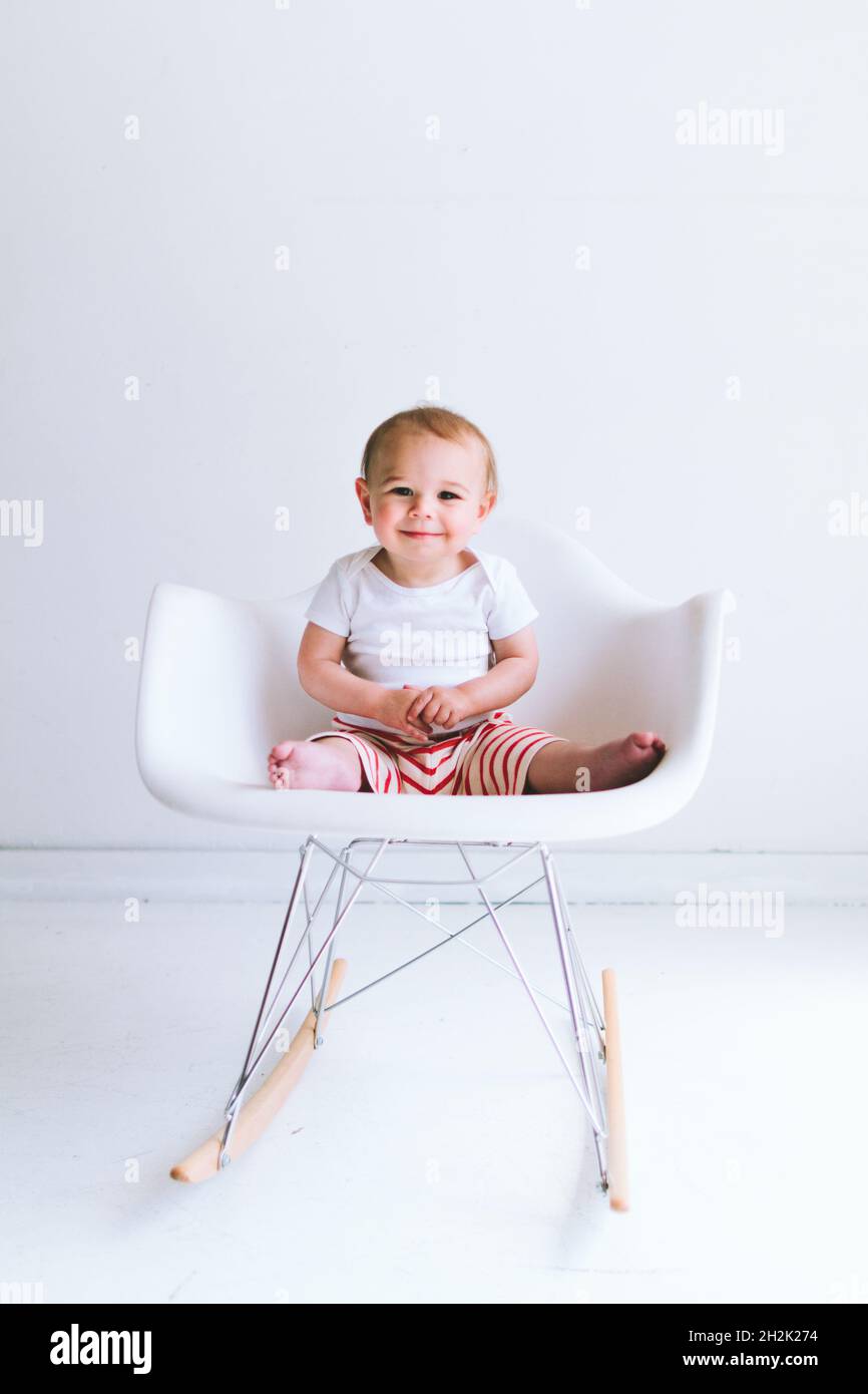 A baby boy sits in a modern shell chair Stock Photo - Alamy
