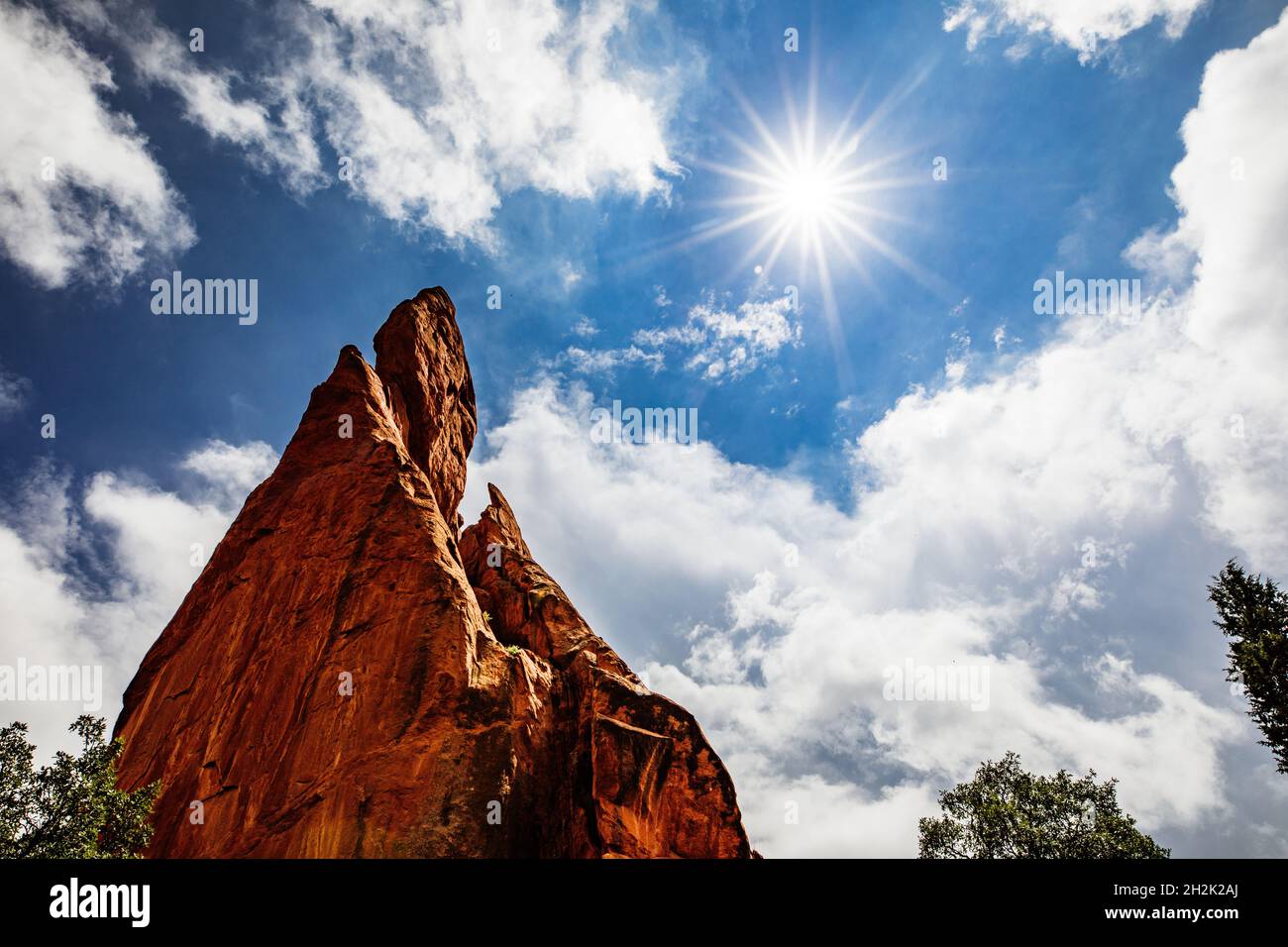 Red rocks cliff in summer sun burst Stock Photo - Alamy