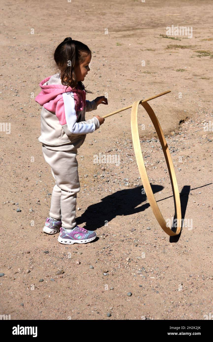 A child plays with a replica of a popular 19th century rolling hoop toy ...