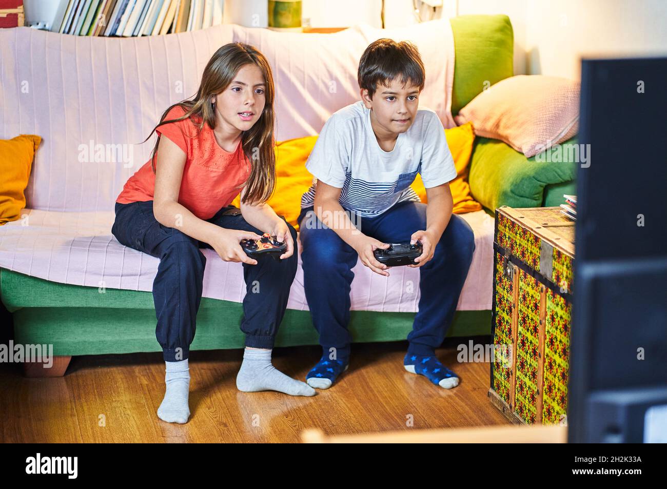 Children playing video games together in living room Stock Photo - Alamy