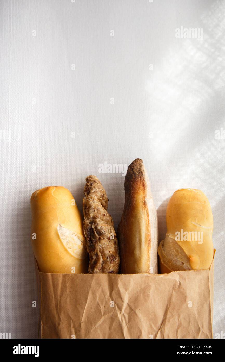 rye, wheat, multigrain baguettes in a paper bag on a white background ...