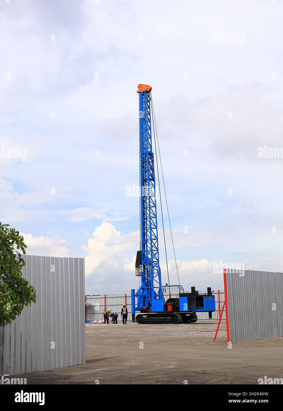 engineers and hammer pile driving machine working on construction area ...