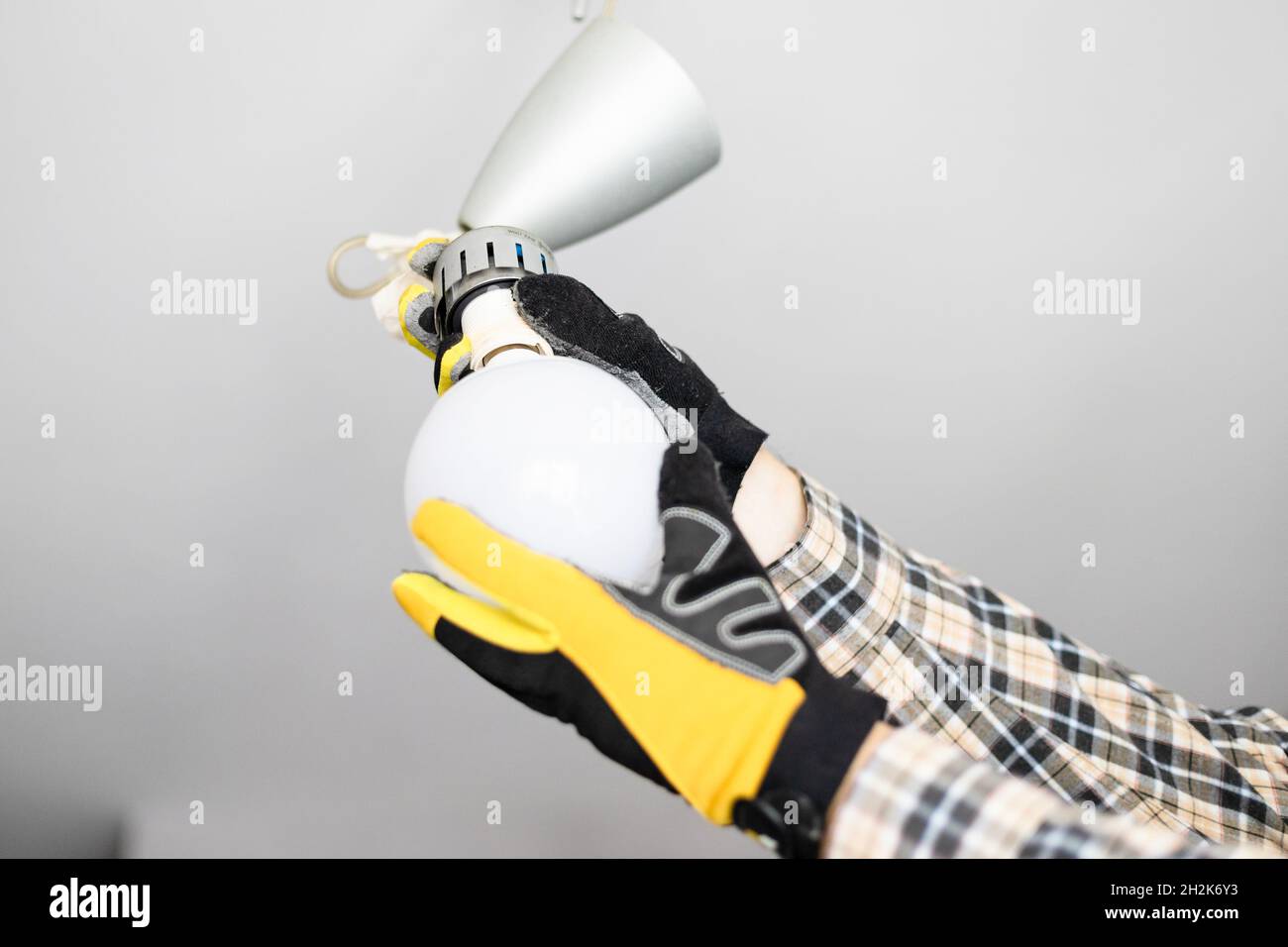 electrician removing bulb from fault ceiling light at home Stock Photo ...