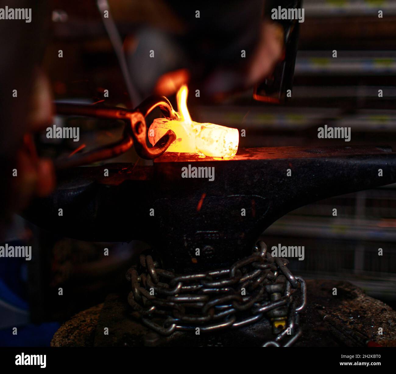 Closeup of forging a small piece of metal in the workshop with a blurry ...