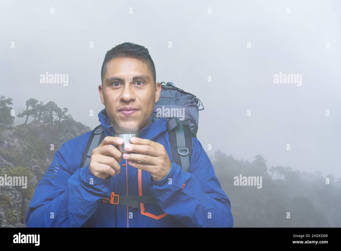 Hispanic backpacker drinking coffee from a thermos flask cup against a ...