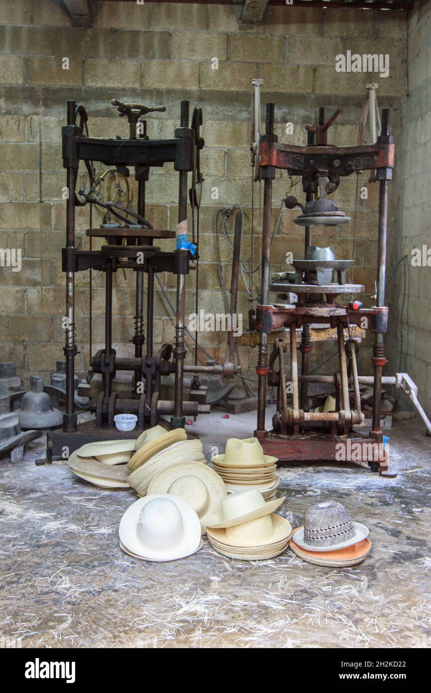Vertical shot of two hat making machines and many cute hats on the ...