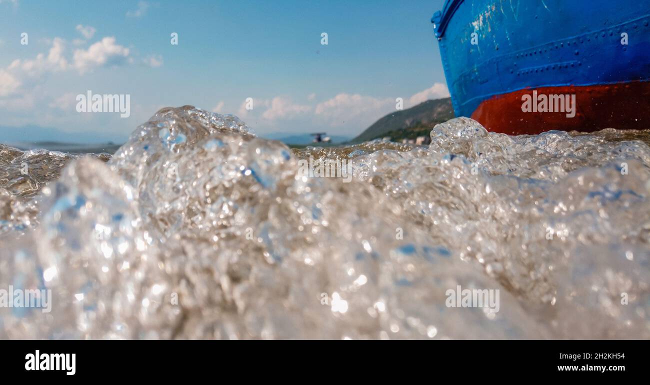 Waves hit the blue boat on the lake shore, underwater Stock Photo - Alamy