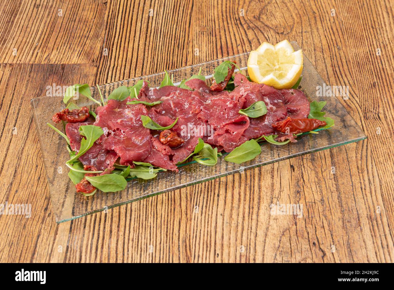 Italian dish of raw beef marinated with salt and olive oil covered with ...