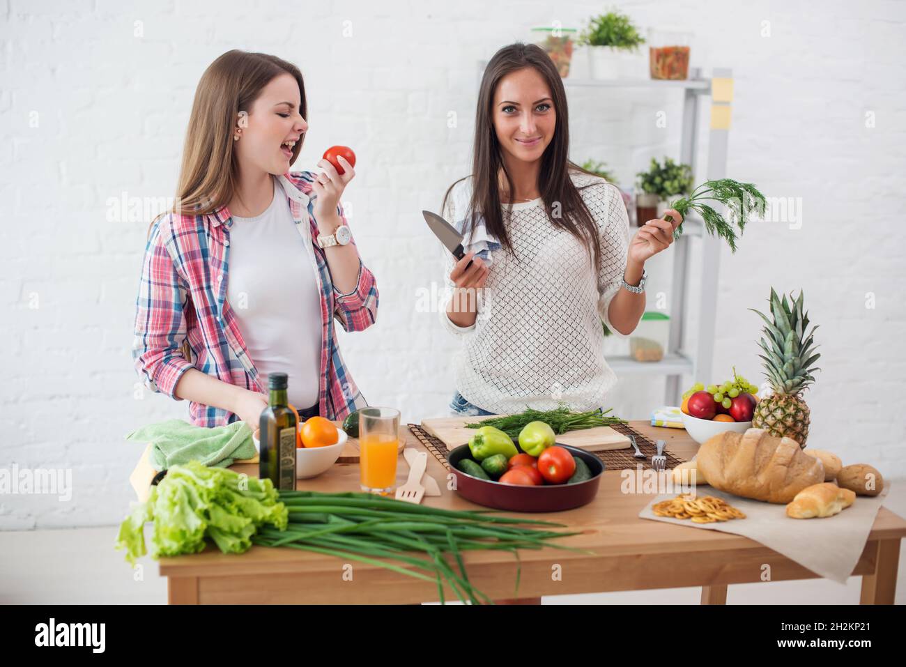 Two girls friends preparing dinner in a kitchen concept cooking ...