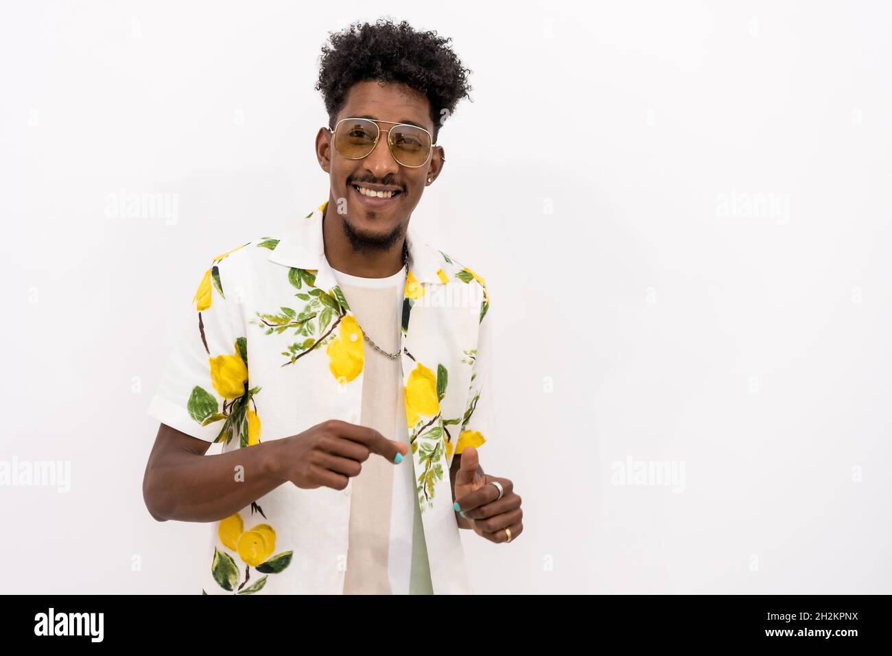 Young Cuban male in a floral shirt and black sunglasses moving and ...