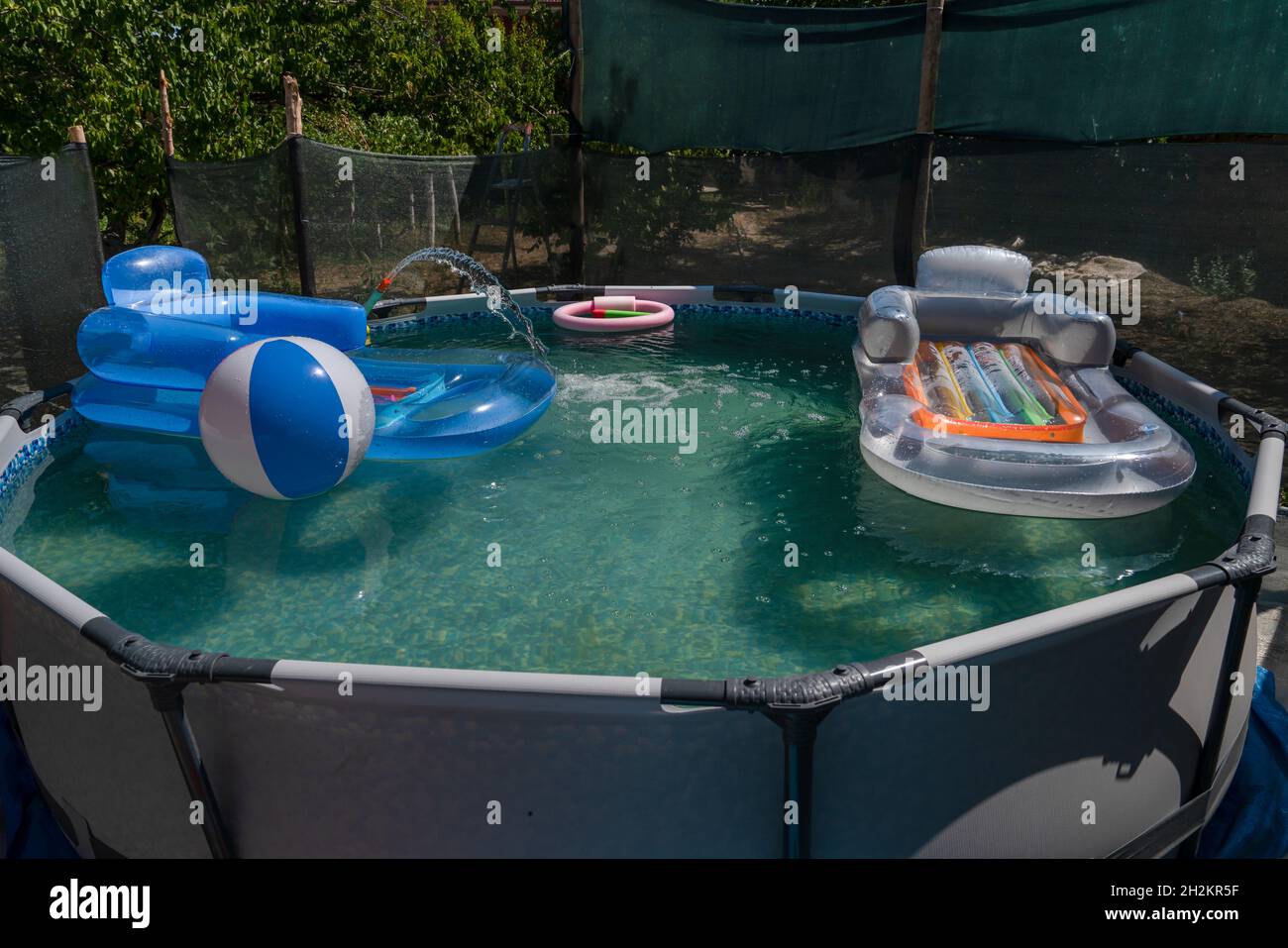 Blue plastic pool in the garden Stock Photo - Alamy