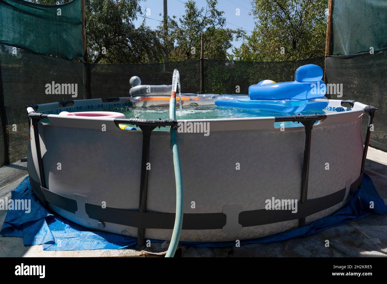 Blue plastic pool in the garden Stock Photo - Alamy