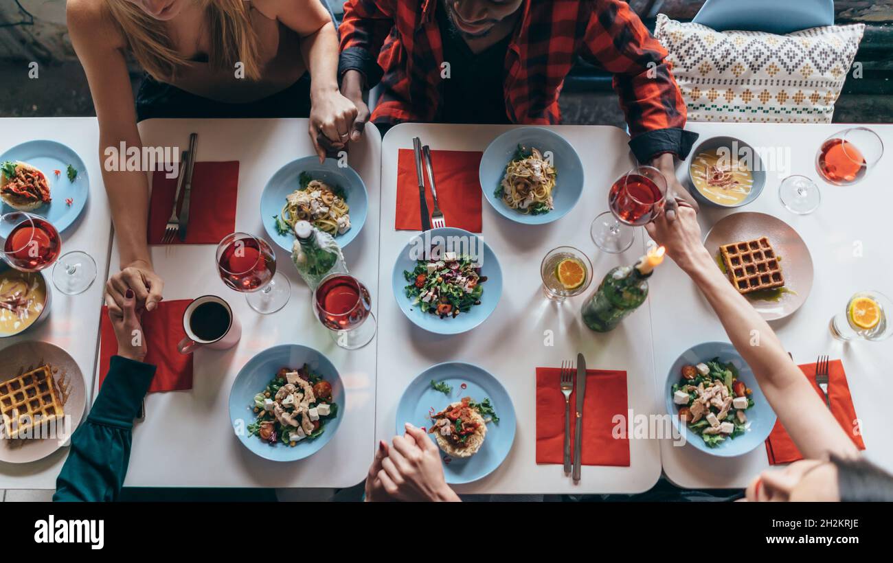 Group of friends pray before having food. Top view of Family gathering ...