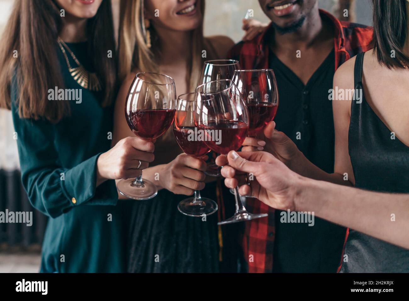 People enjoying drinks at cafe. Friends at bar toasting wine and ...