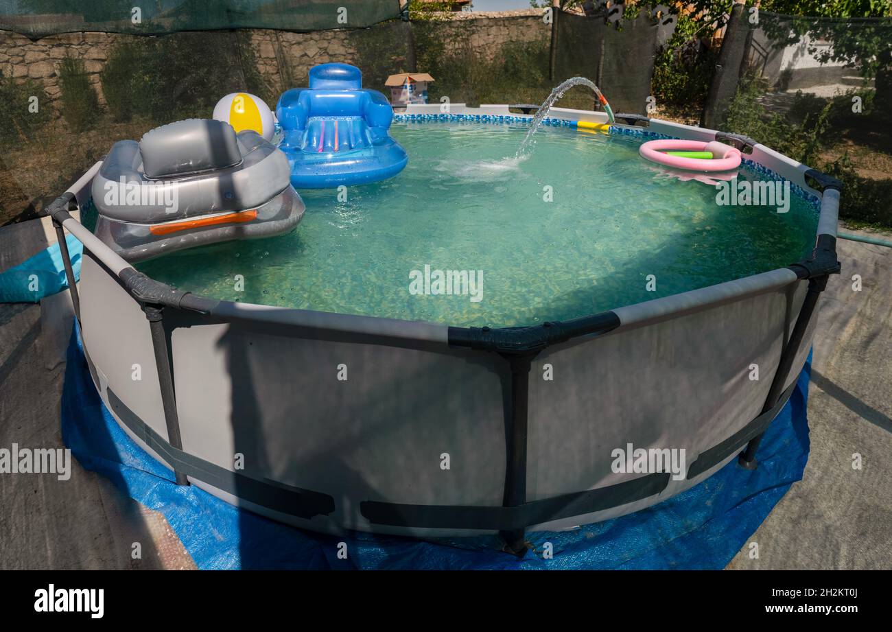 Blue plastic pool in the garden Stock Photo - Alamy