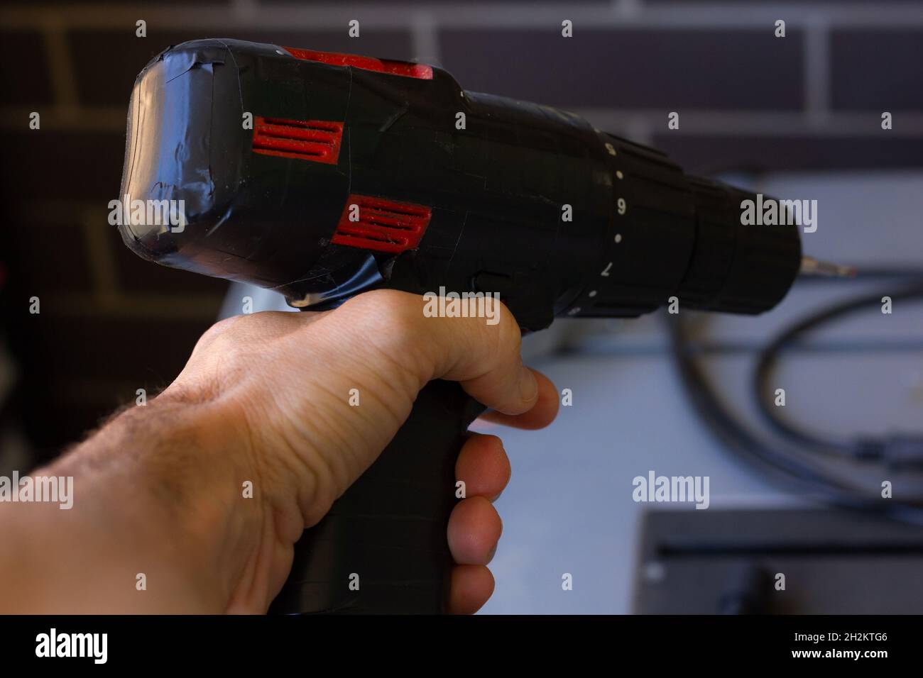 Hand of man holding drill wrapped in black tape. Hardware worker tool ...