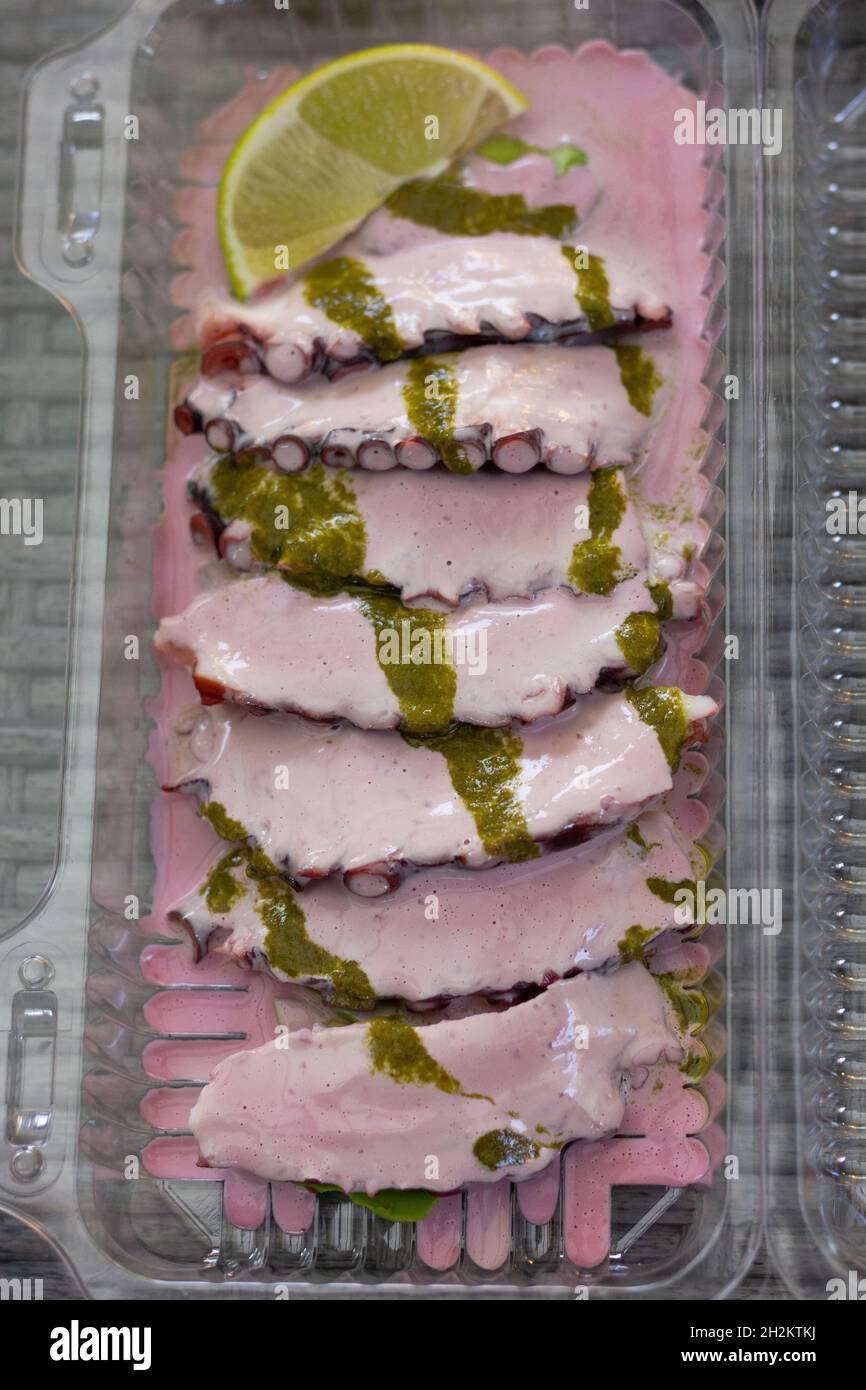 Octopus slices covered in pink sauce and lemon slice on transaparent ...
