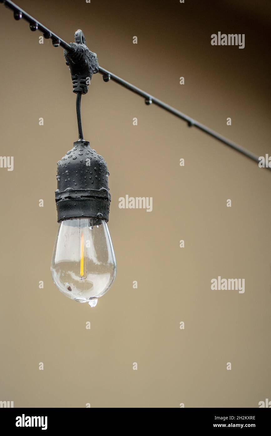 Bistro string light covered in drops of water - damp outside dining in ...