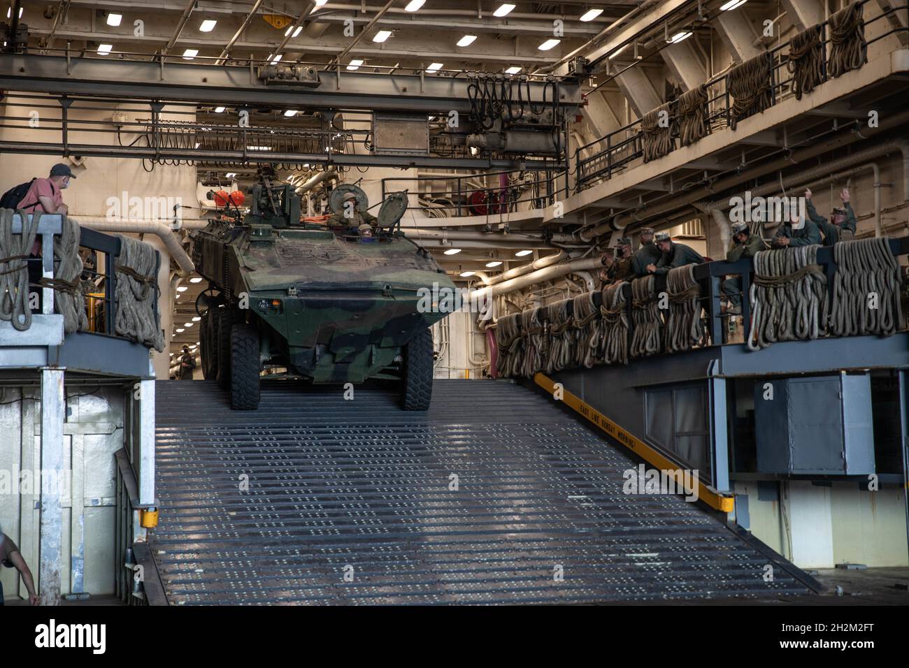 U.S. Marines and Sailors load an amphibious combat vehicle (ACV), with ...