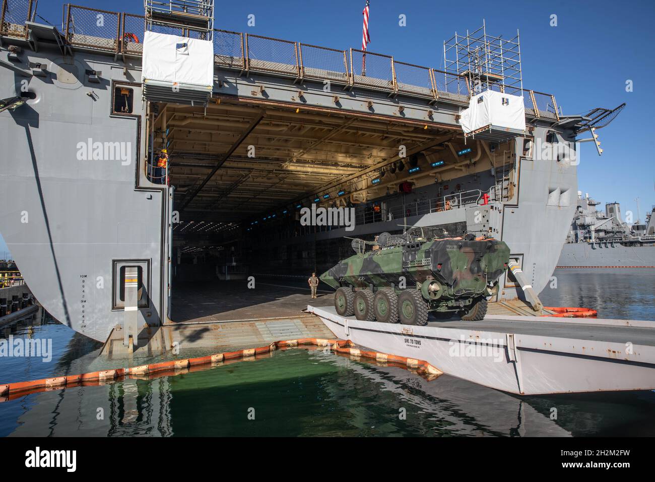 U.S. Marines and Sailors load an amphibious combat vehicle (ACV), with ...