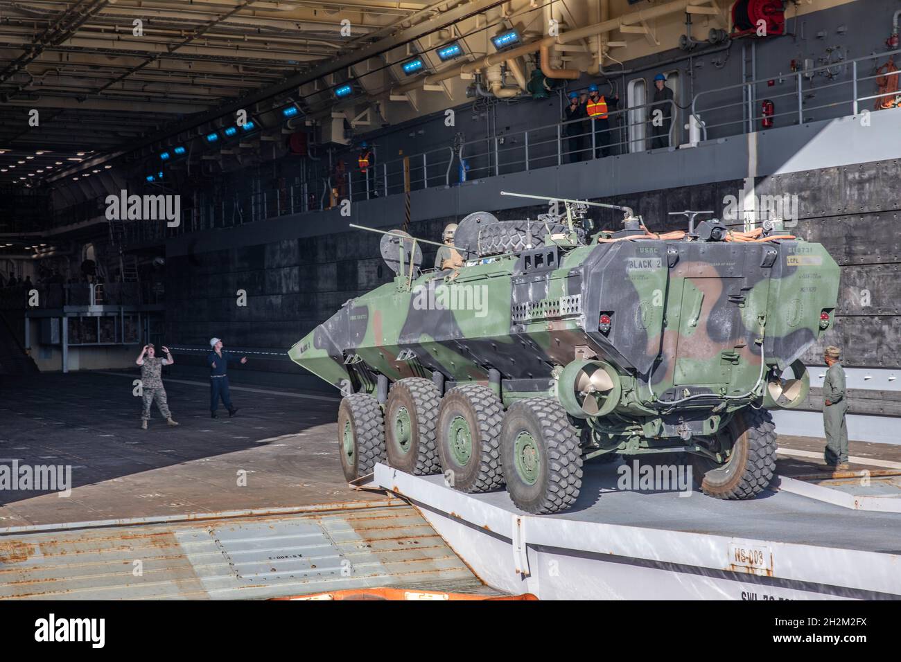 U.S. Marines and Sailors load an amphibious combat vehicle (ACV), with ...