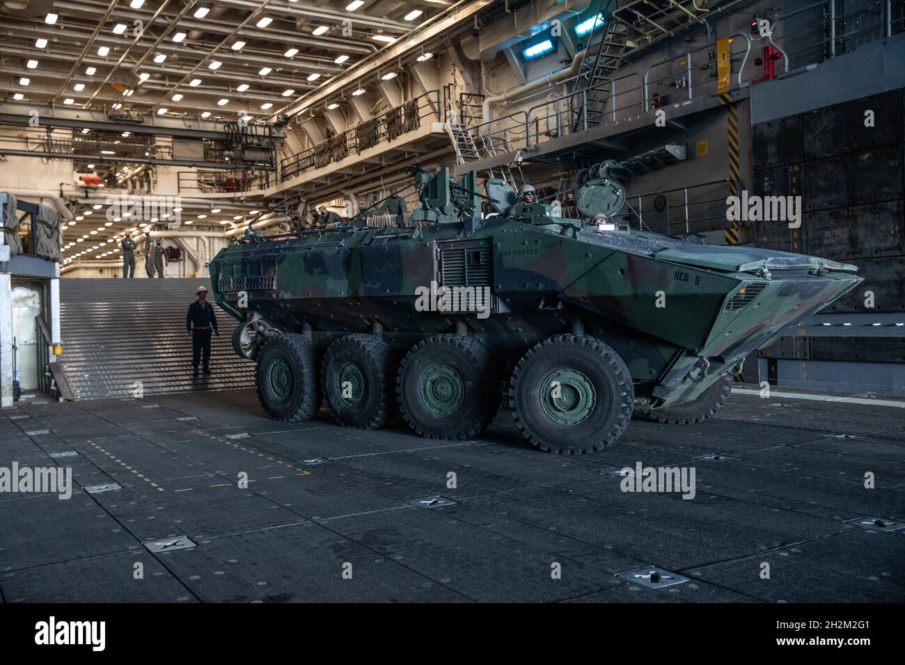 U.S. Marines and Sailors load an amphibious combat vehicle (ACV), with ...