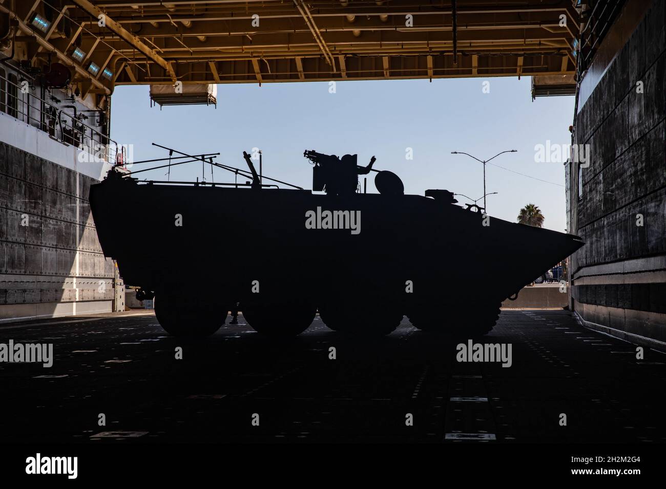 U.S. Marines and Sailors load an amphibious combat vehicle (ACV), with ...