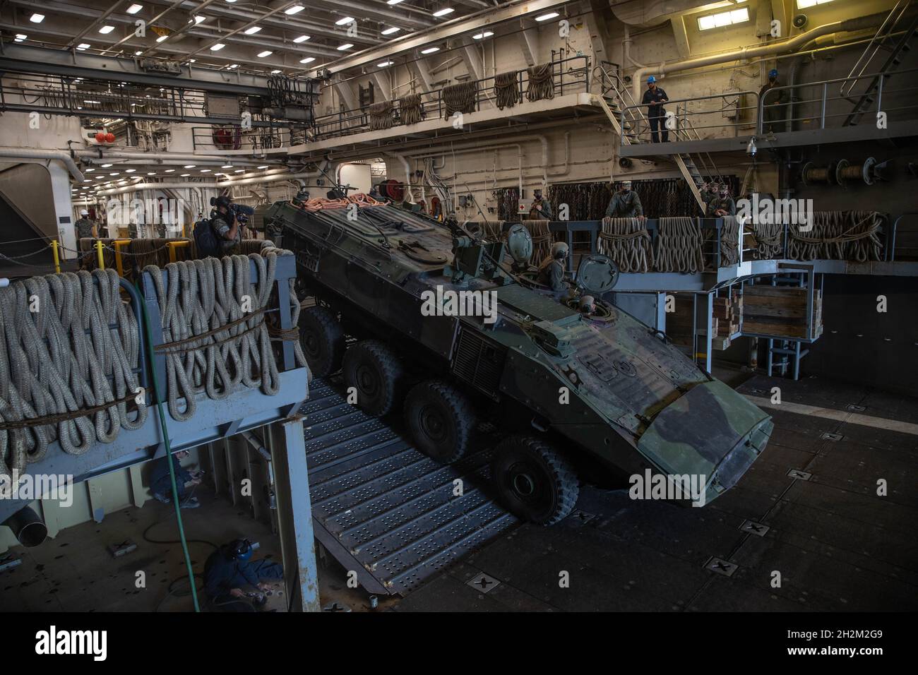 U.S. Marines and Sailors load an amphibious combat vehicle (ACV), with ...